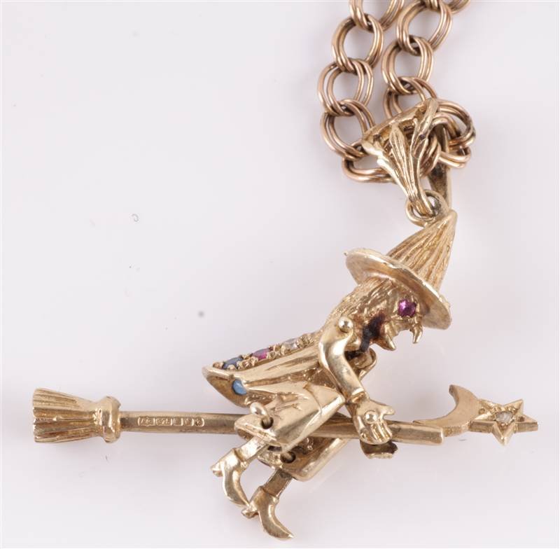 A 9 carat gold articulated stone set witch pendant