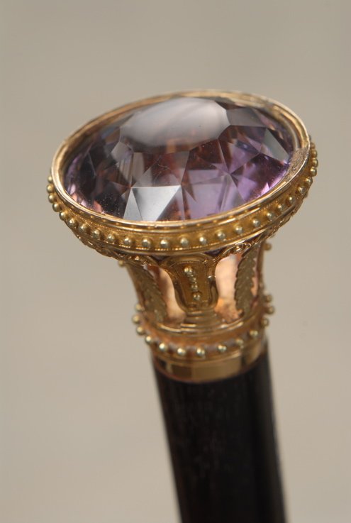 10: A beautiful gold cane with a large inset amethyst