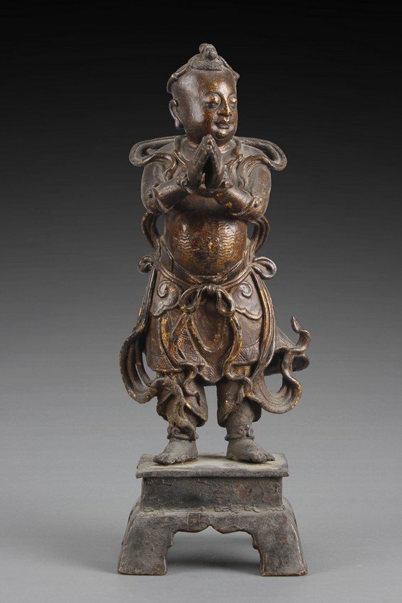 A carved bronze 'Praying Boy' statue