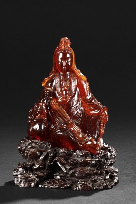 A VERY RARE CARVED AMBER FIGURE OF GUANYIN