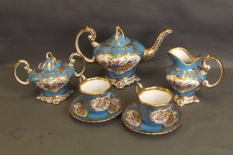 A Blue Ground Kpm Tea Set With Floral Panels And Gilt