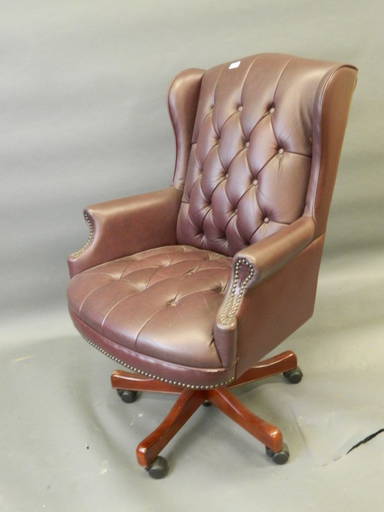 A Tilt And Swivel Wingback Desk Chair With Button Back