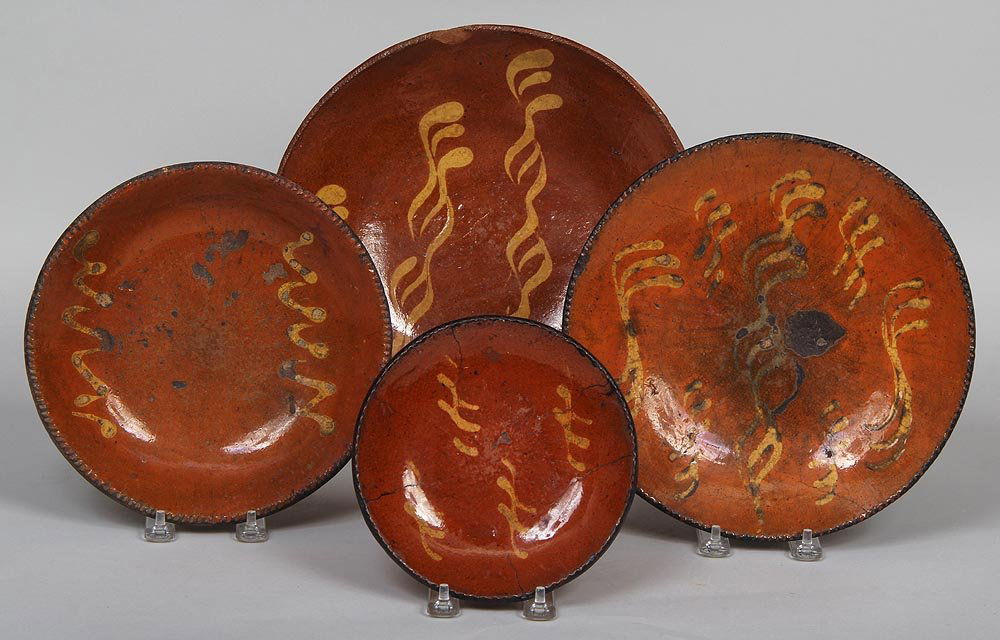 Group of (4) redware plates with yellow designs,