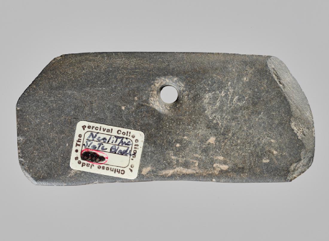 A BLACK STONE AXE BLADE