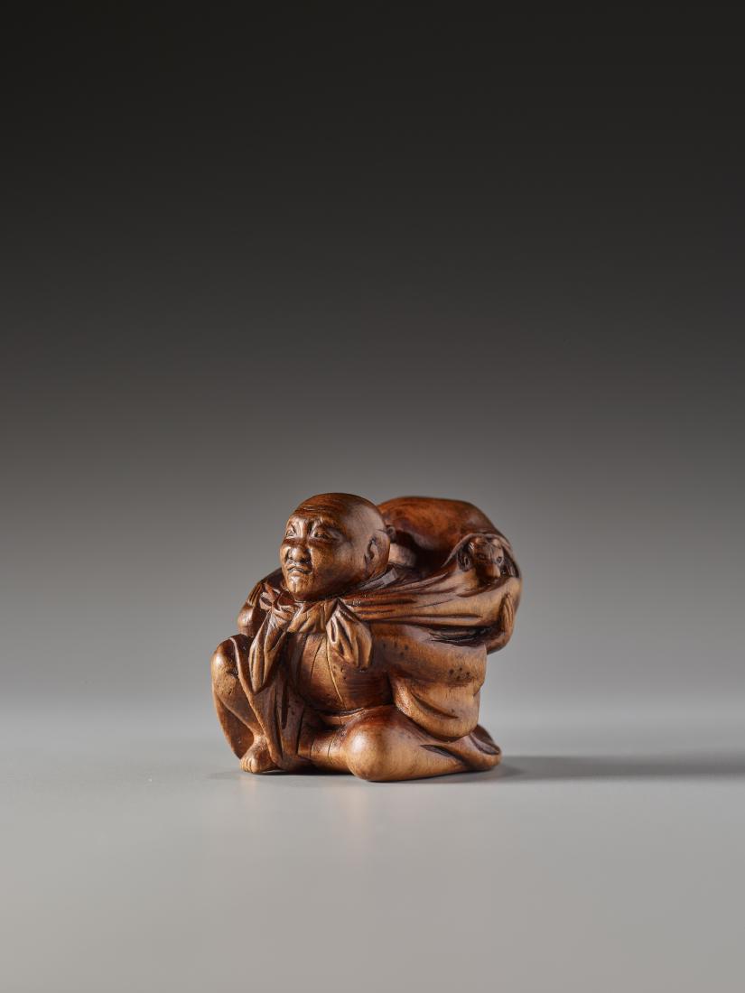A WOOD NETSUKE OF A HUNTER AND FOX BY HIDEMASA