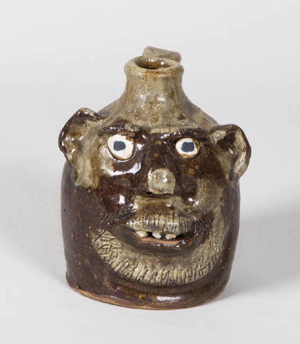 SMALL GROTESQUE FACE JUG White eyes and teeth, signed