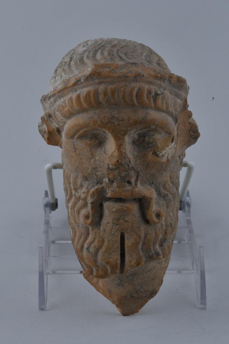 Ancient carved stone. Greek style head of a bearded man