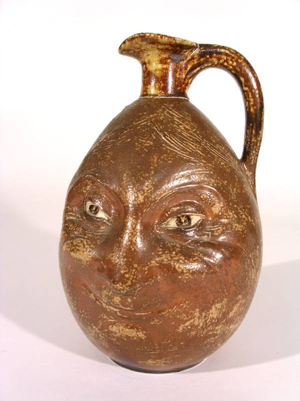 407: Art Pottery double faced grotesque jug signed "R.W