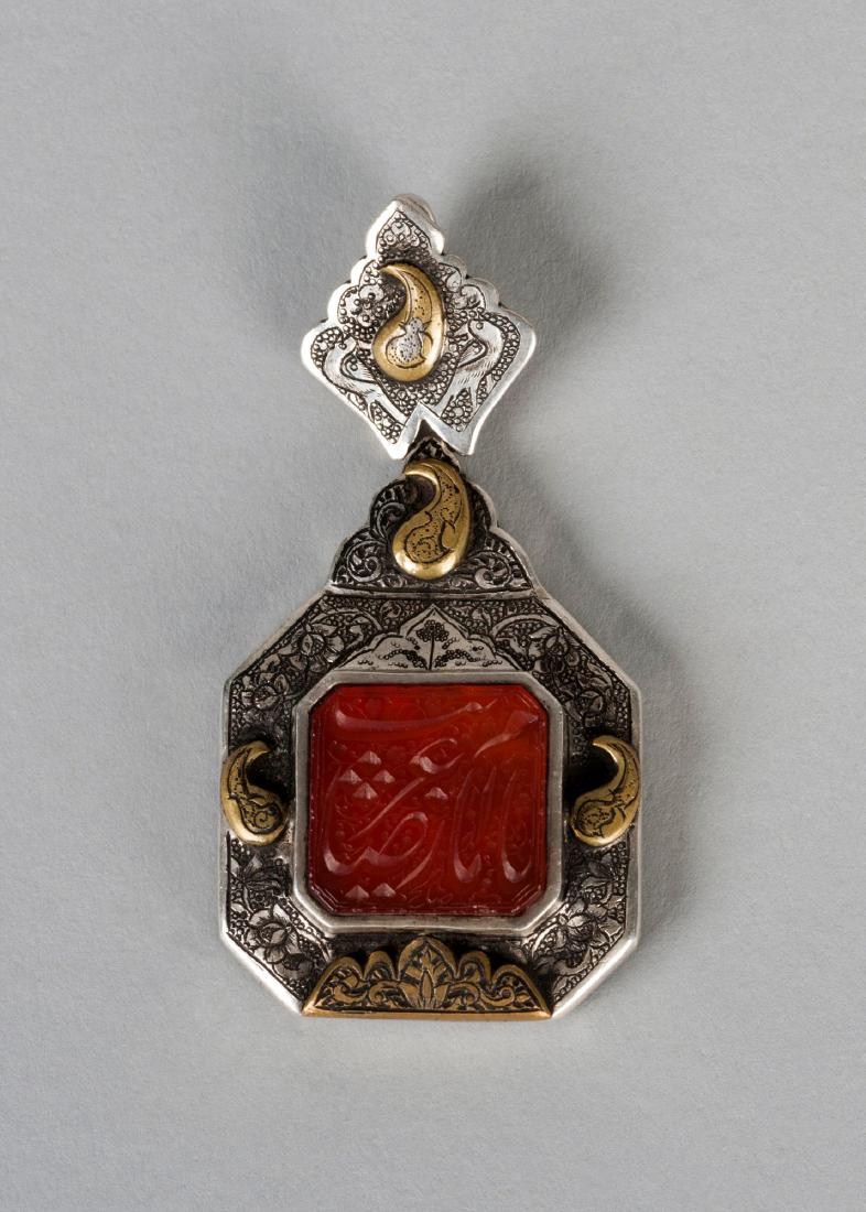 A Qajar carnelian and silver mounted amulet , Iran,