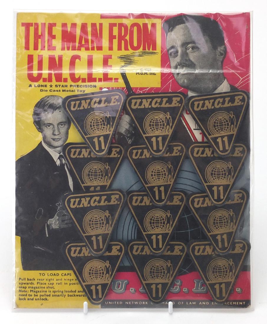 Twelve 1960's The Man from Uncle badges, with cardboard