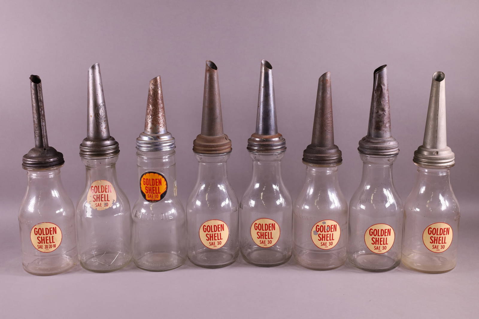 Eight Golden Shell Oil Bottles Auction