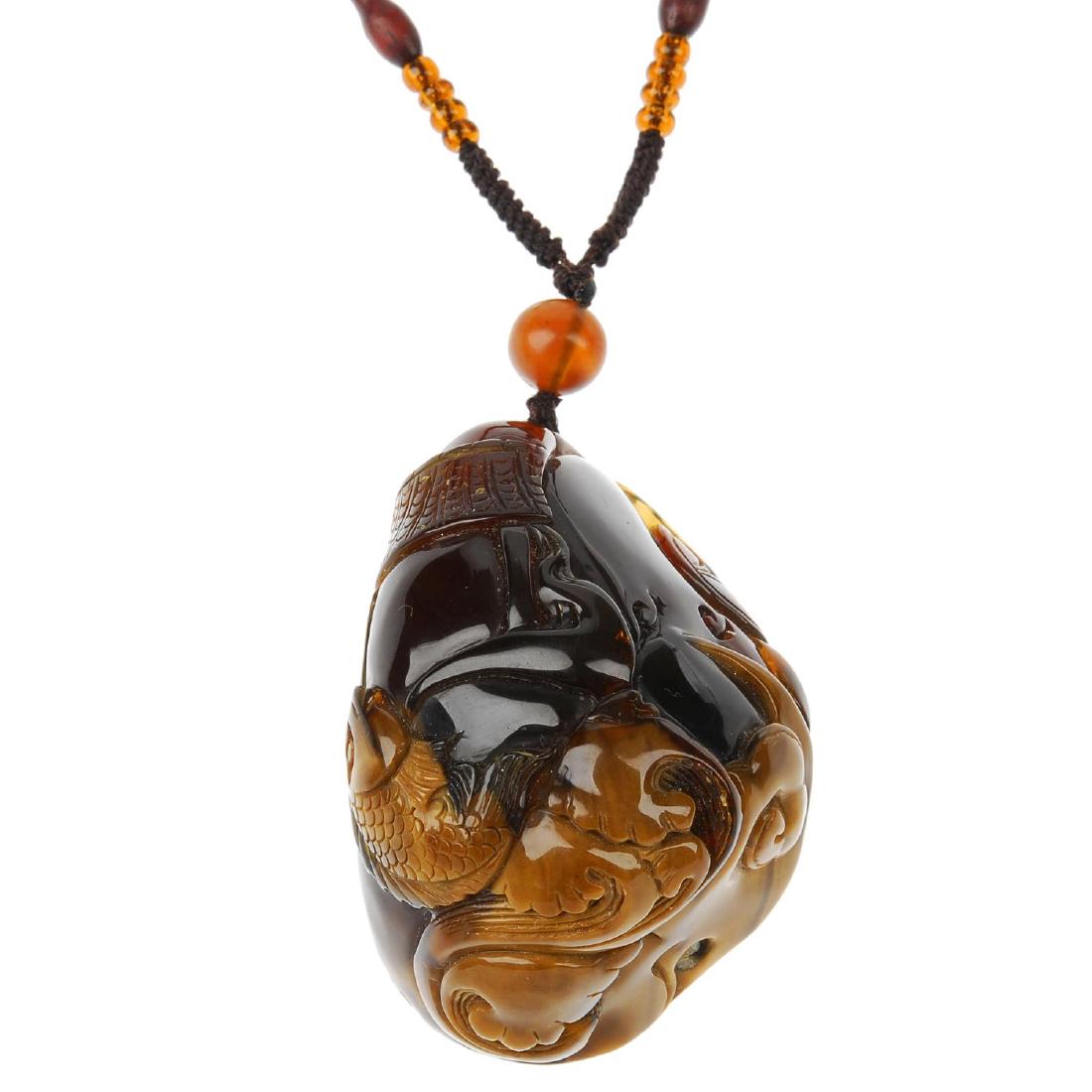 A natural Burmese carved root amber pendant. The