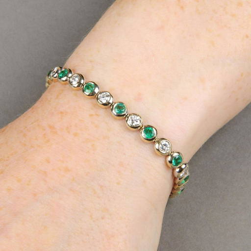 An Emerald And Brilliant Cut Diamond Collet Line