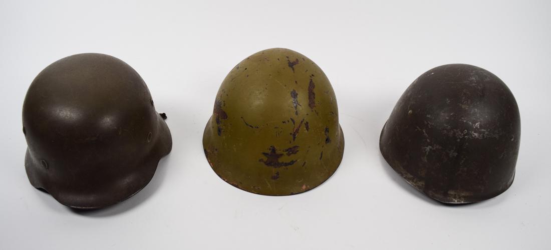 Group of World War II Axis military helmets.