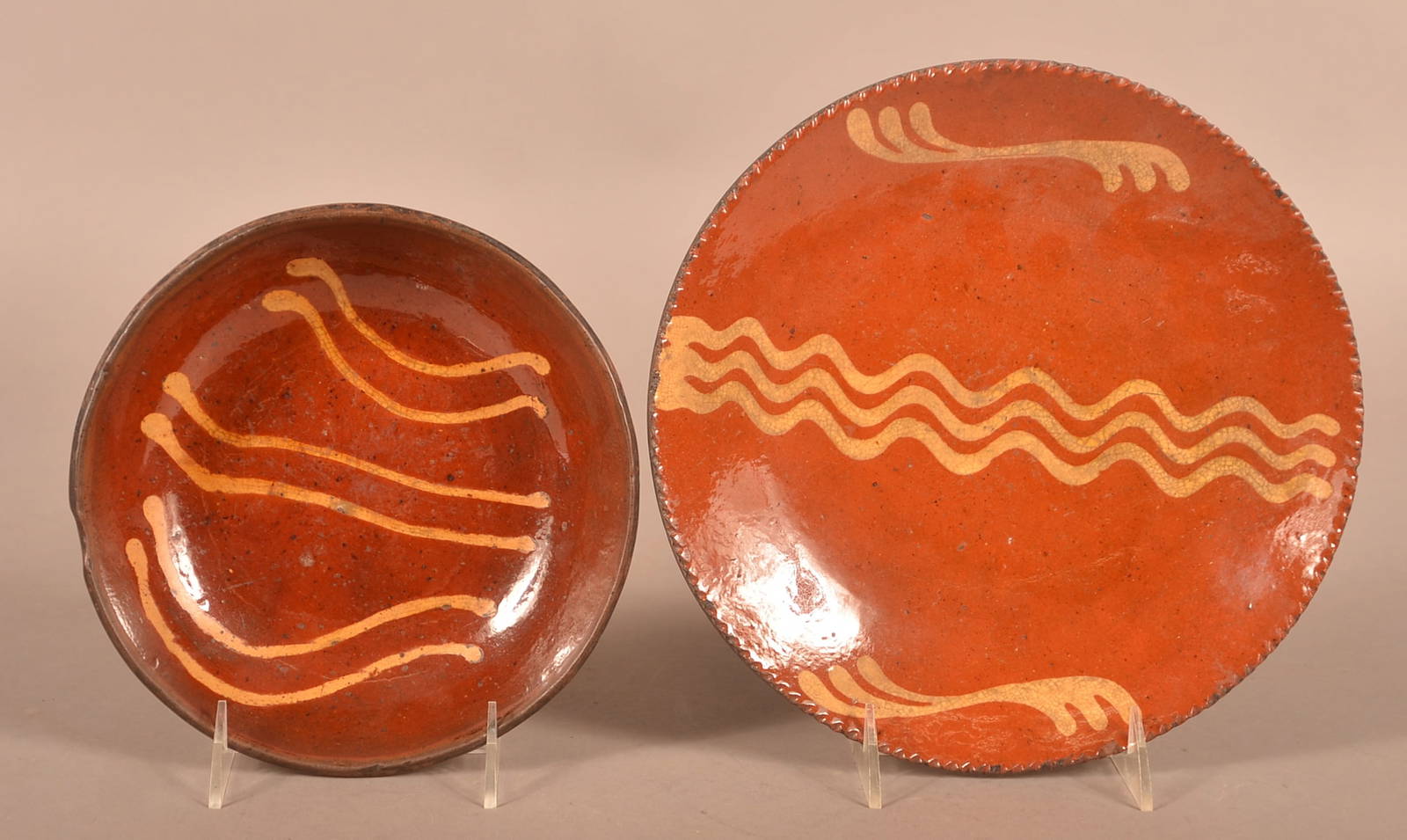 Two Yellow Slip-decorated Redware Plates. Auction