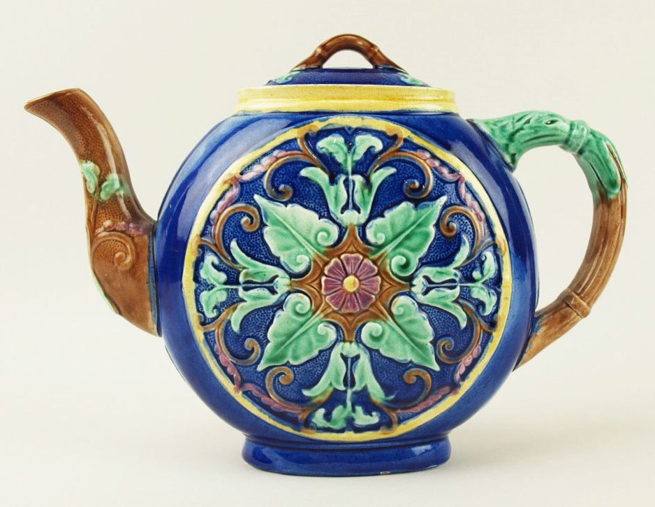 A Majolica moon shaped teapot decorated with stylized
