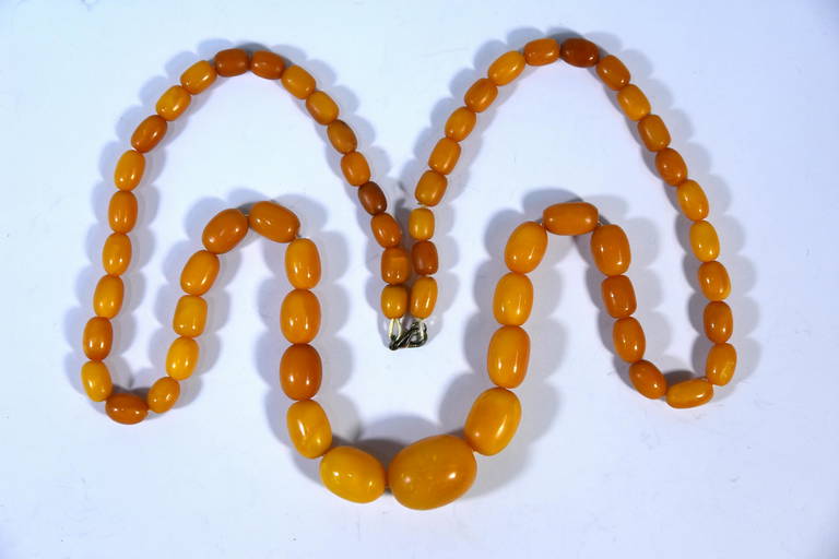 A Row Of Graduated Orange Amber Beads