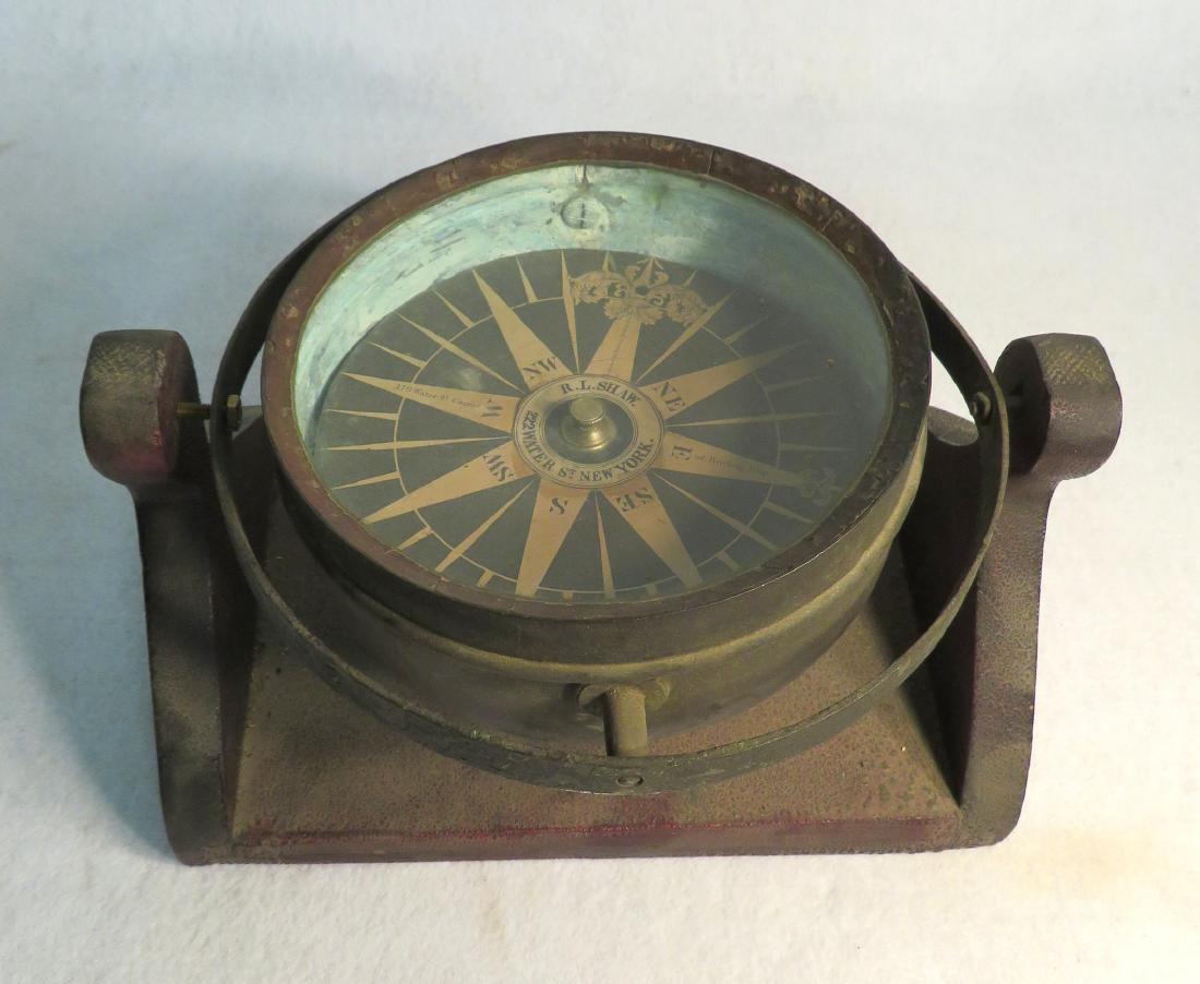 Ship's compass mounted on a primitive wooden stand in