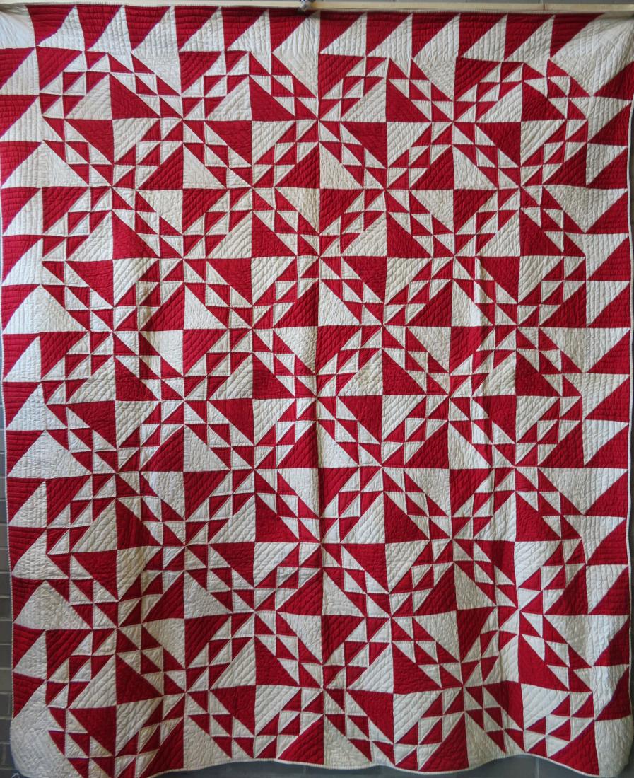 Red and white patchwork quilt with sawtooth border, all