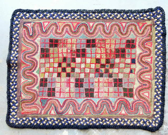 A good folk art hooked rug having a postage stamp center surrounded by ...