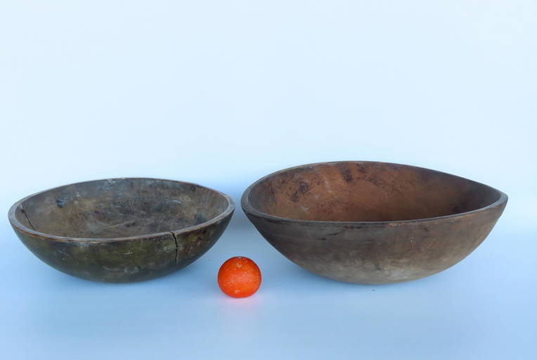 Two primitive treenware mixing bowls. The largest with molded edge in ...