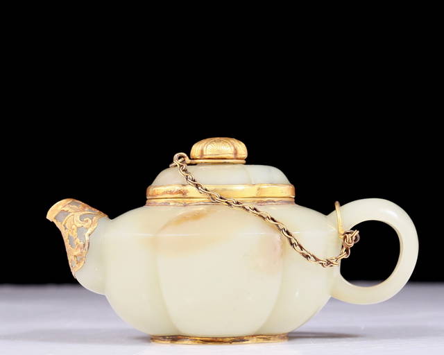 An Exquisite White Jade Teapot Covered With Gold And Floral Patterns